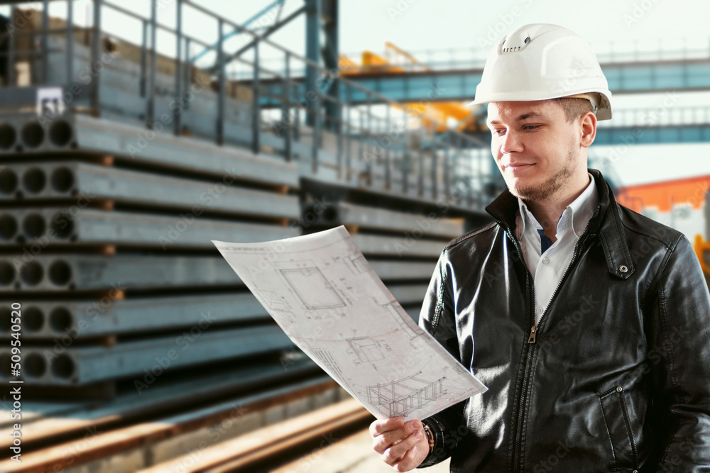 civil engineer holds a blueprint in his hands against the background of ...