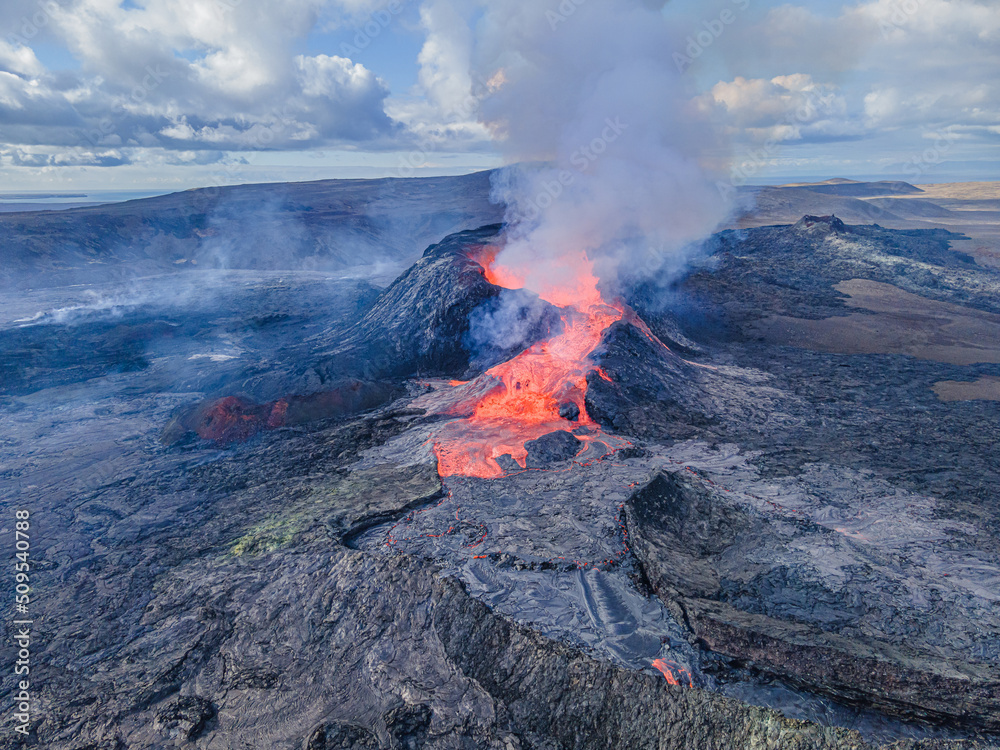 glowing hot lava pouring out of a volcano in Iceland. View into the ...
