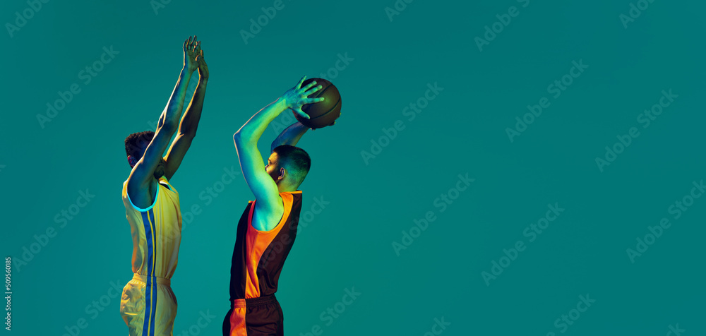 Portrait of two young men, professional basketball players in a jump ...
