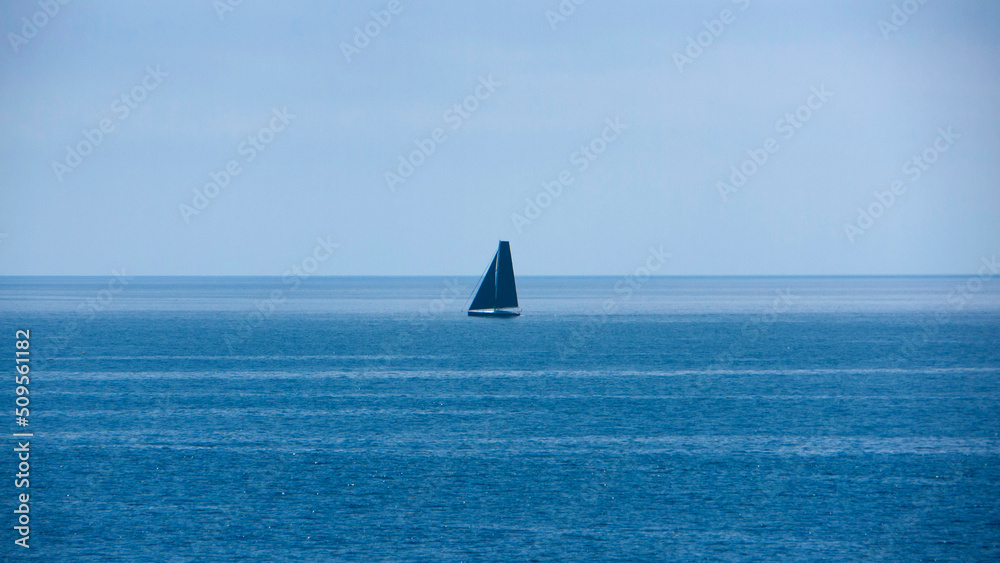 Velero de velas azules en el horizonte de mar mediterraneo Stock Photo ...