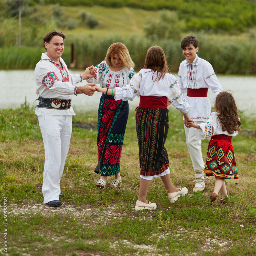 Full length image of a family with kids in traditional romanian clothes ...