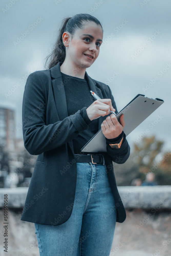 Joven secretaria de cabello moreno formal con una sonrisa de pie ...