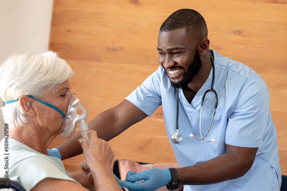 African american male health worker helping caucasian senior woman to ...