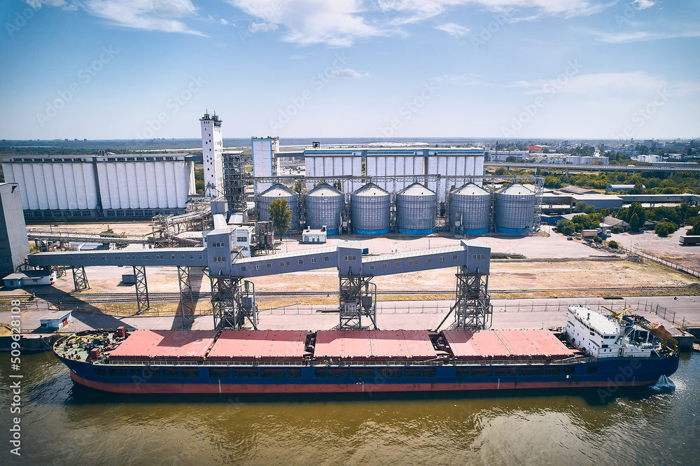 Bulk carrier ship in cargo port. Aerial view of barge in a dock. Grain ...