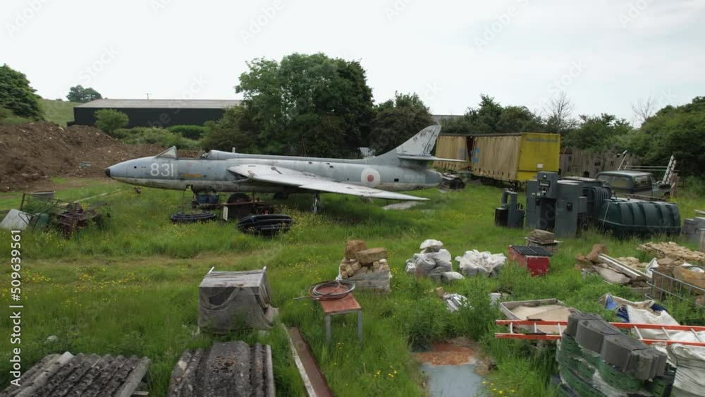 Junk yard British field with discarded Hawker hunter fighter jet side ...