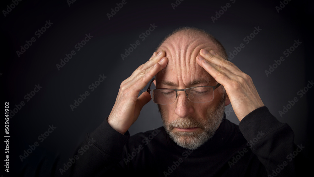 tired - 60 years old man with a beard and glasses massaging his ...
