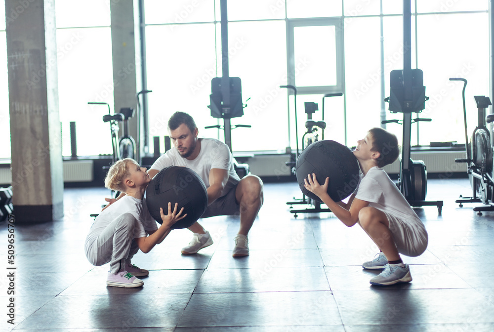 Children's fitness. Two teenager boys are training with a trainer in a ...
