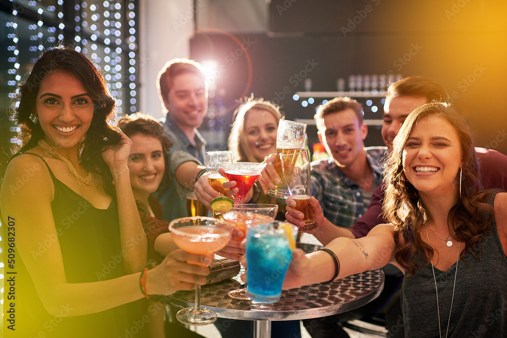 Heres to the good times. Portrait of a group of people toasting with ...
