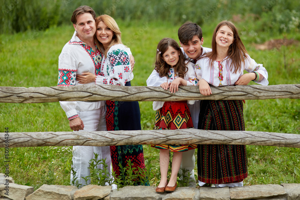 Front view of a beautiful family with kids in traditional clothes ...