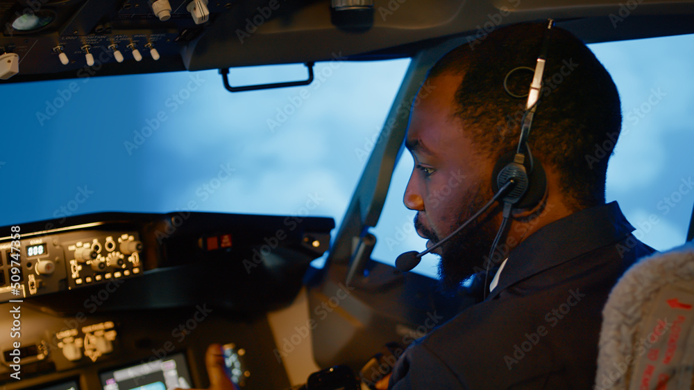 African american copilot using airplane command to fly plane ...