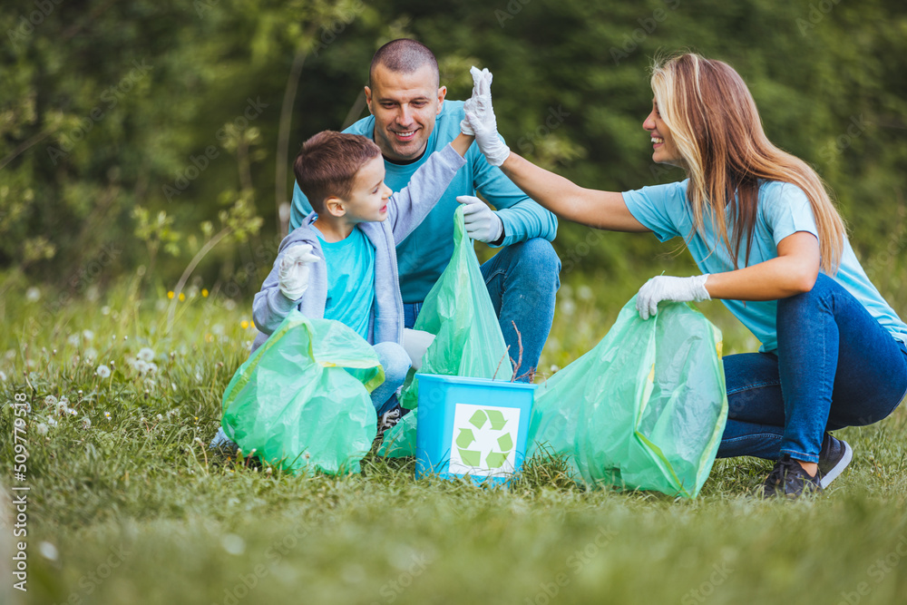 Mother and father teach their son to recycle plastic in recycling ...