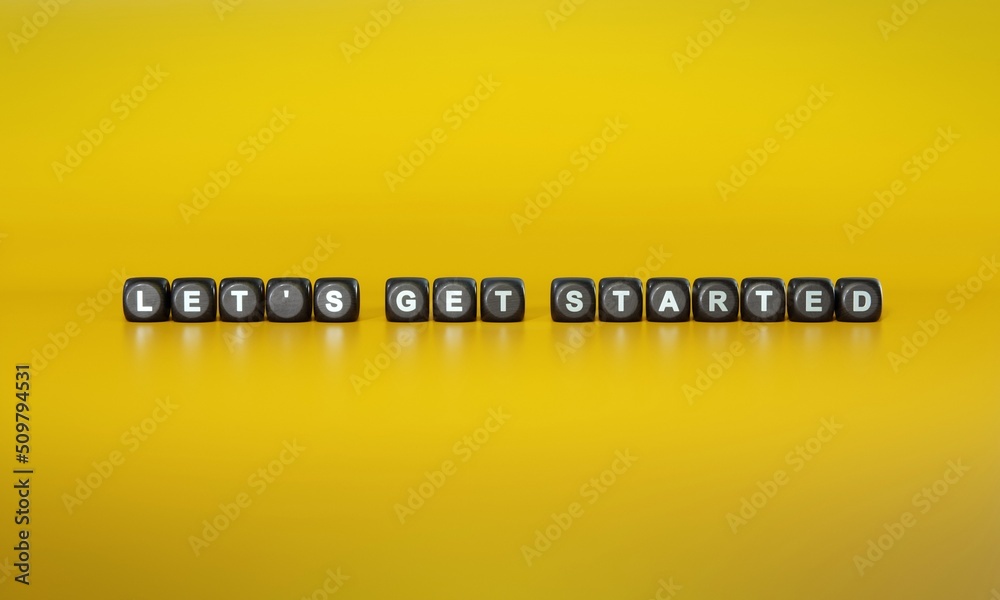 Words ‘Let’s get started’ spelled out in white text on dark wooden ...