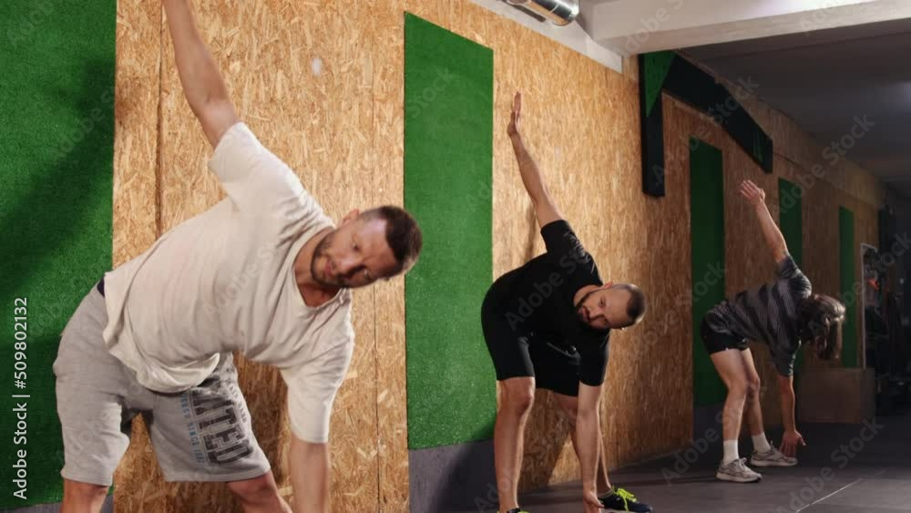 Stretching gymnastic exercise. Men training body in sport gym, standing ...