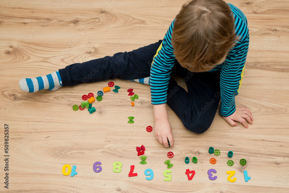 Math with fun. Calculation and marking of uncooked pasta with colored ...