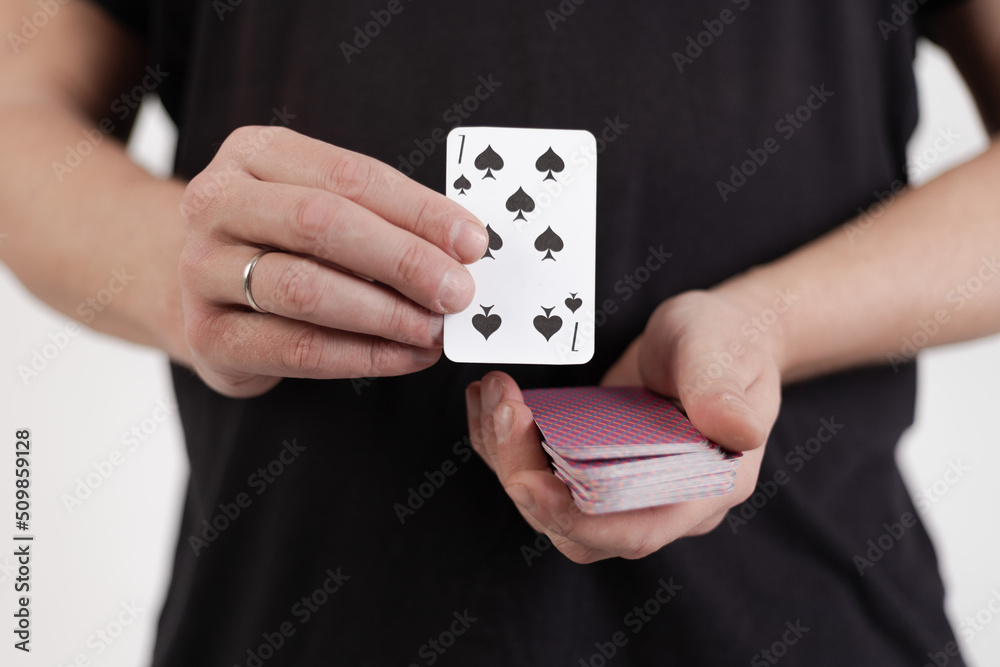 Male hands hold a deck of cards and show tricks. The photographer is ...