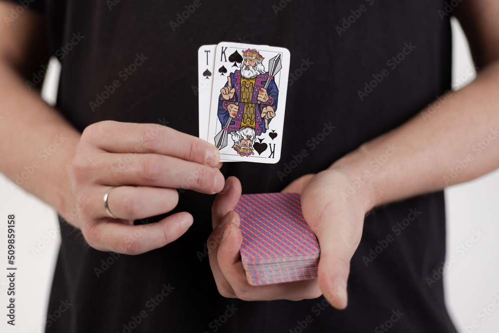 Male hands hold a deck of cards and show tricks. The photographer is ...