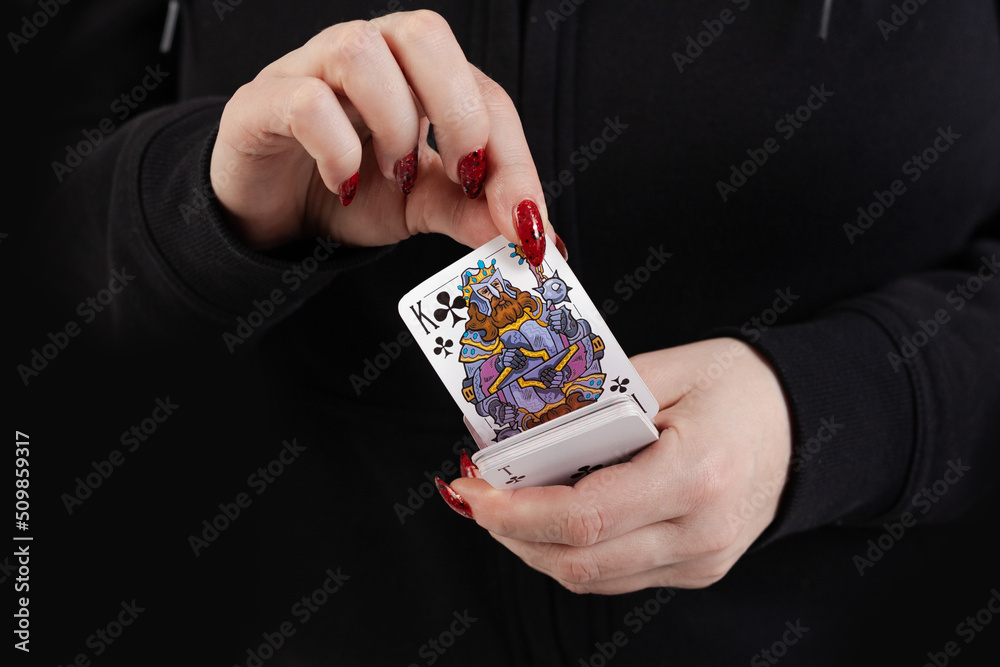 Female hands hold a deck of cards and show tricks. The photographer is ...