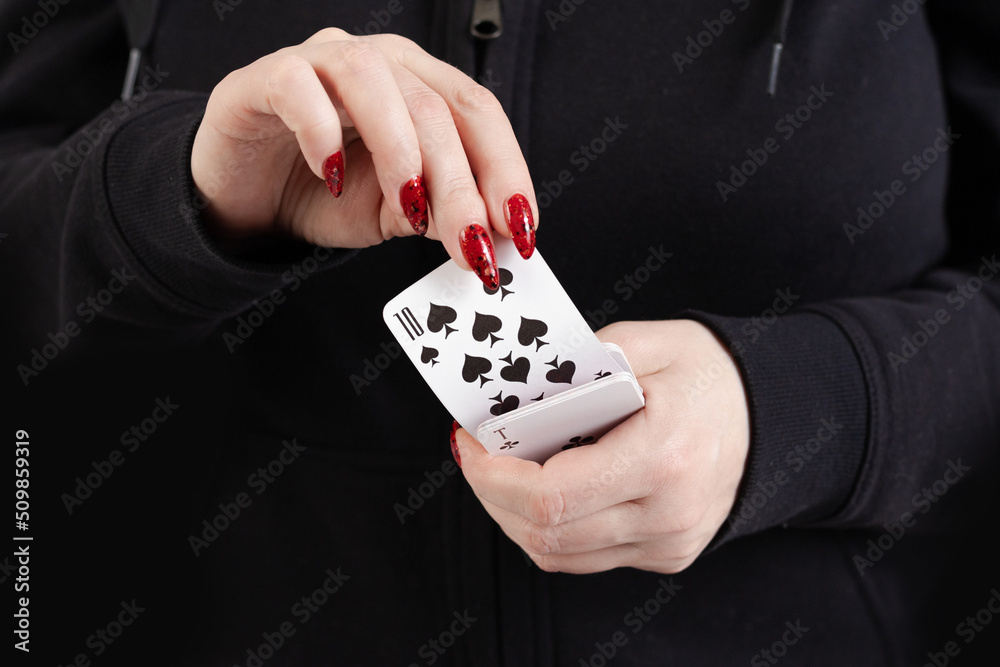 Female hands hold a deck of cards and show tricks. The photographer is ...