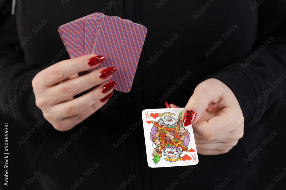 Female hands hold a deck of cards and show tricks. The photographer is ...