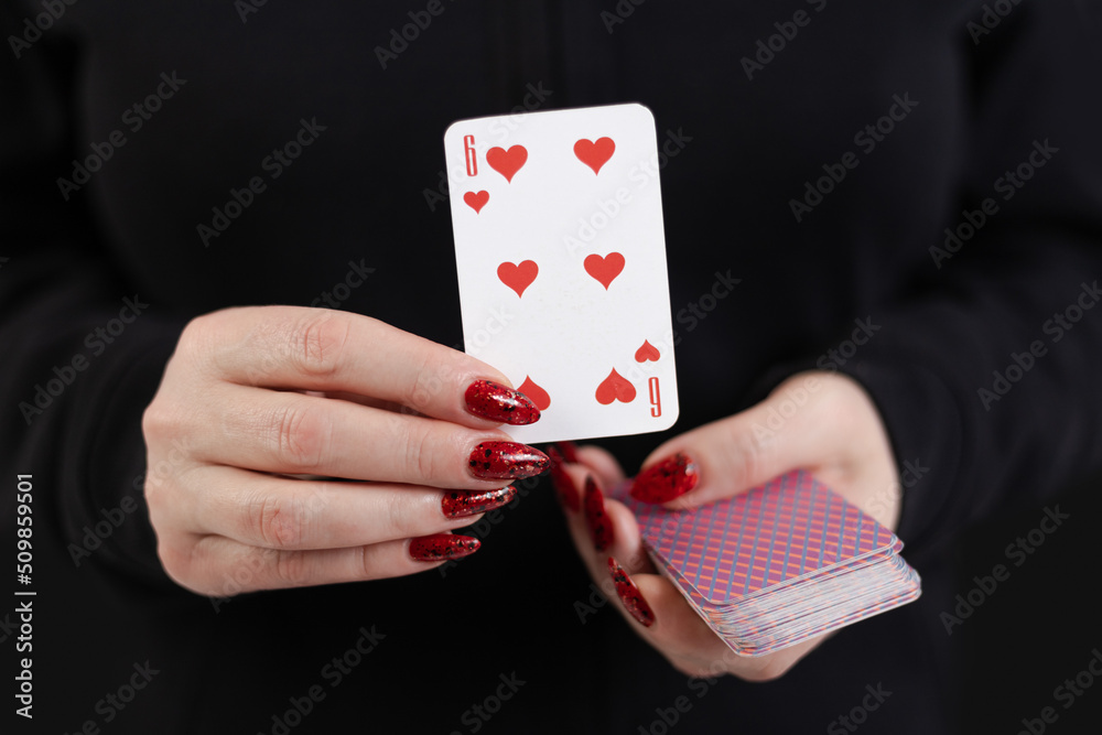 Female hands hold a deck of cards and show tricks. The photographer is ...