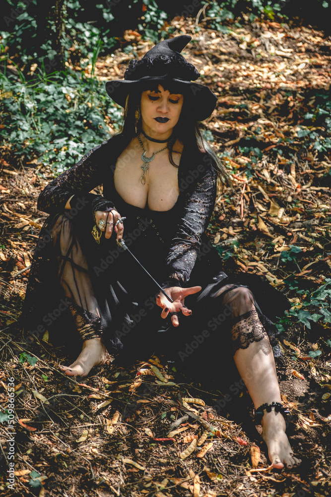 Beautiful young, gothic, sexy and witch woman from with stylized hands with black nails and ...