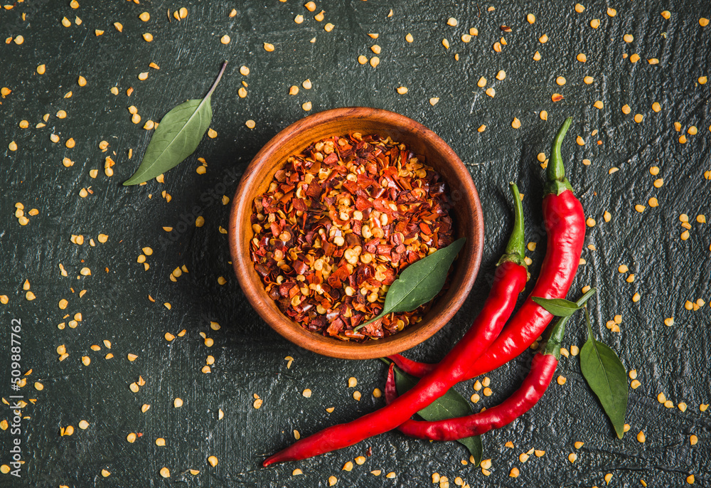Dry chili pepper flakes and fresh chili peppers. Bowl of crushed hot ...