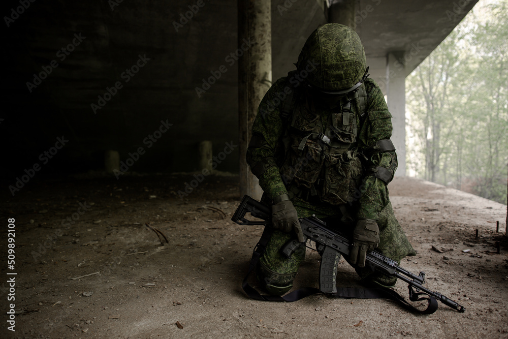 Military soldier in uniform sitting on his knees with his head down ...
