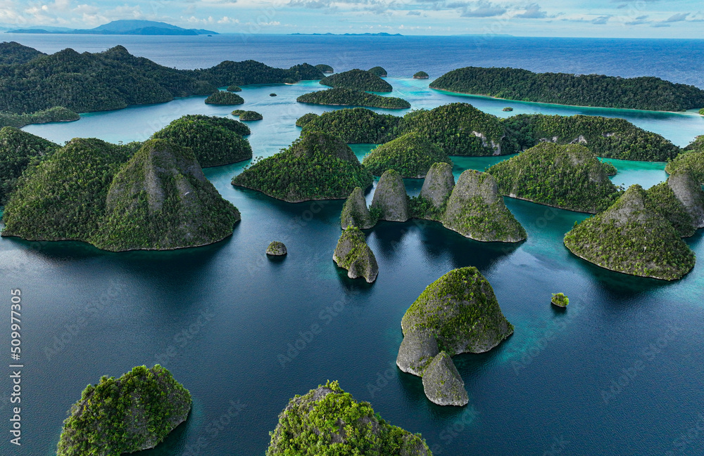 Aerial view of scattered islands with blue ocean water at Wajag Island ...