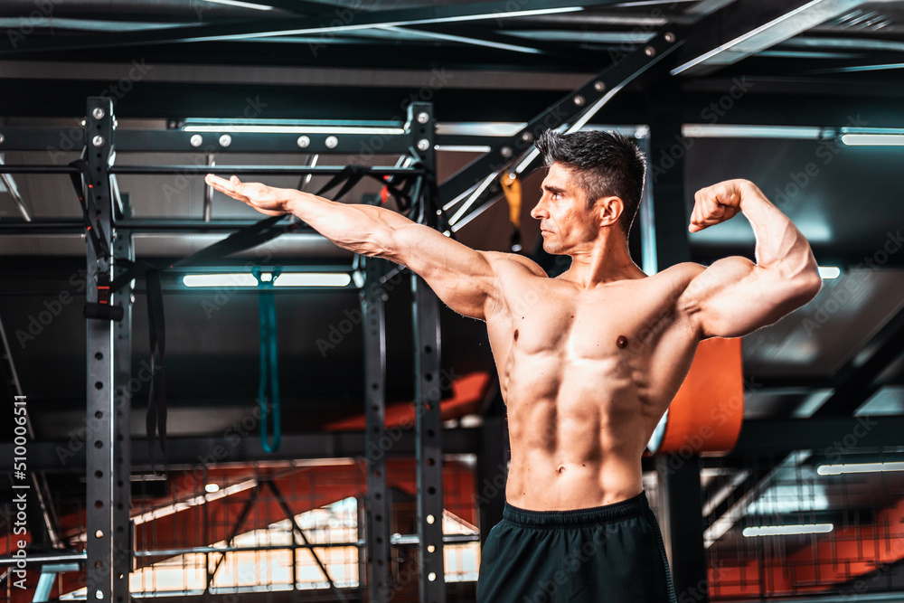 Athletic man posing. Photo of man with perfect physique at the gym ...