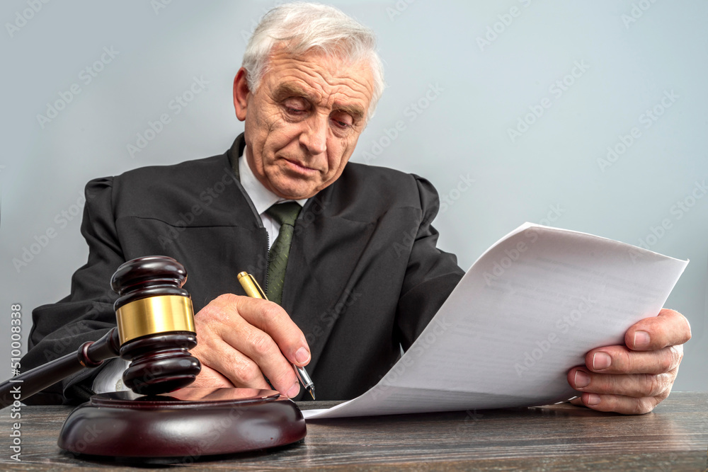 Judge signing the verdict. Judge's gavel on the table in the courtroom ...