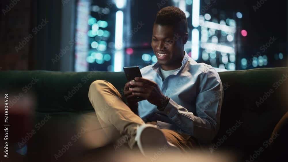 Excited Black African American Man Using Smartphone while Sitting on a ...