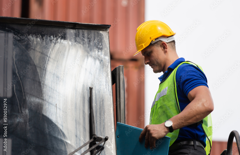 Engineer in hardhat on stacker lifting container control loading ...