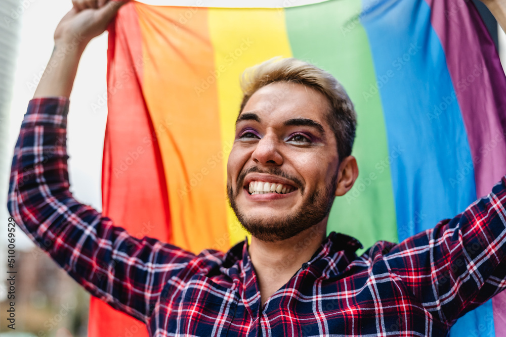 Happy gay man celebrating pride festival holding rainbow flag symbol of ...