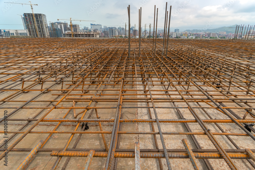 Stacks of square metal and rusty reinforcing rods and mesh for building ...