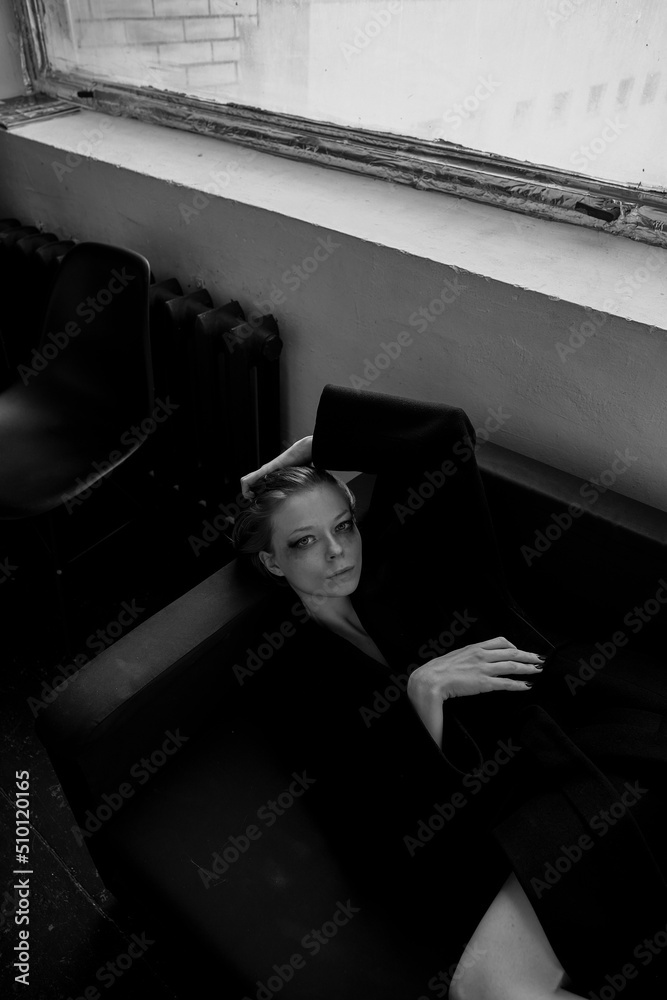 black and white portrait of a fragile girl with a strong look, lying on ...