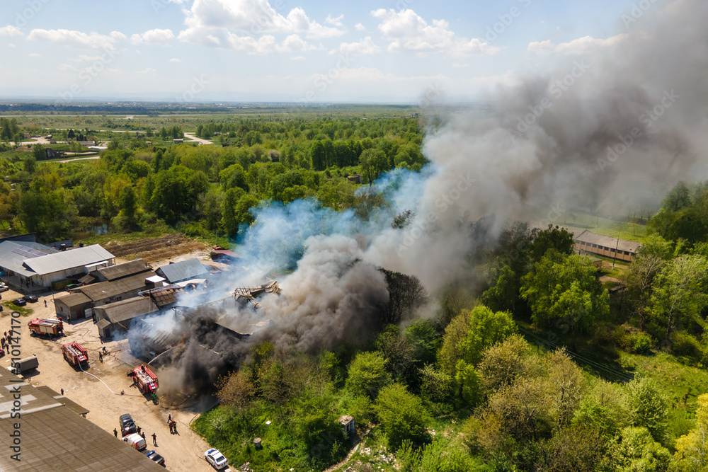 Aerial view of firefighters extinguishing ruined building on fire with ...