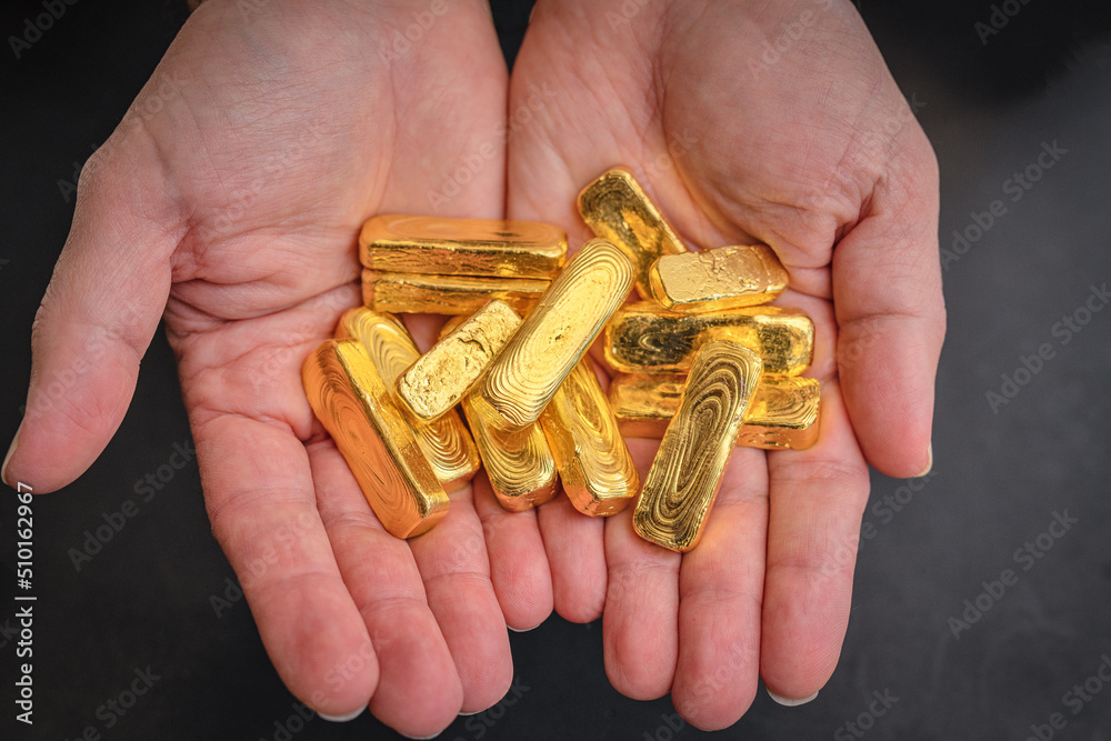 Hands holding solid gold bars Stock Photo | Adobe Stock