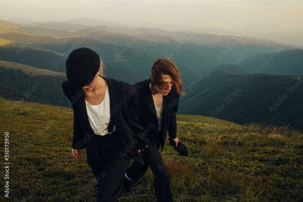 Stylish couple in black suits on a walk among mountain landscapes Stock ...