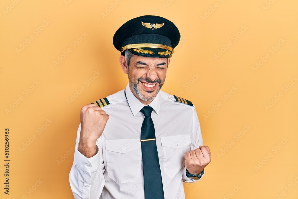 Handsome middle age man with grey hair wearing airplane pilot uniform ...