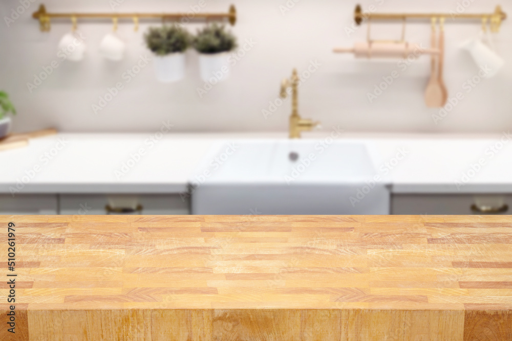 Wooden table over kitchen blurred counter background. Interior for mock ...