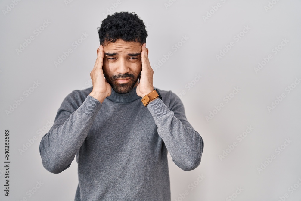 Hispanic man with beard standing over white background with hand on ...