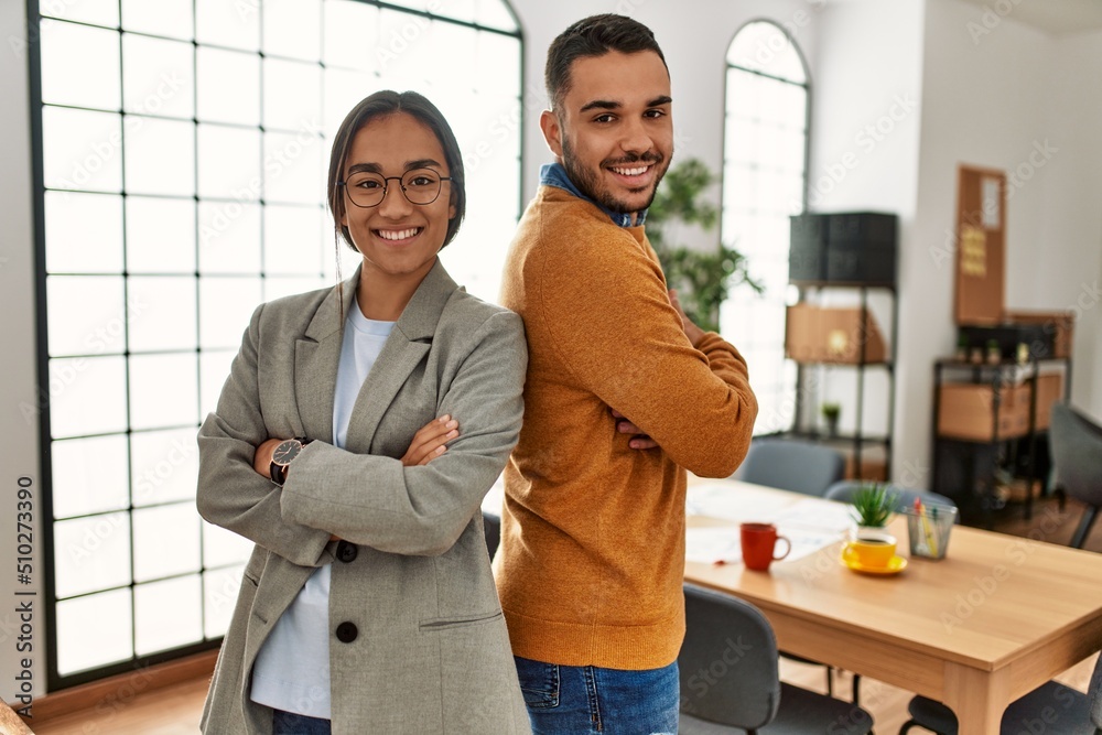 Two business workers smiling happy standing with arms crossed gesture ...