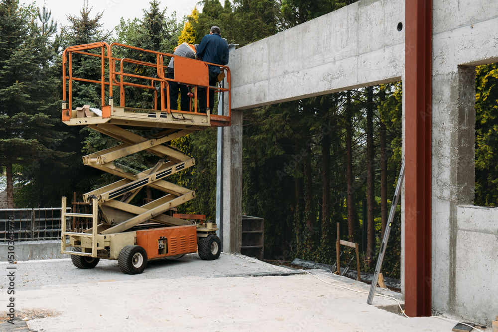 Scissor Lift Platform with workers on a construction site. Building ...