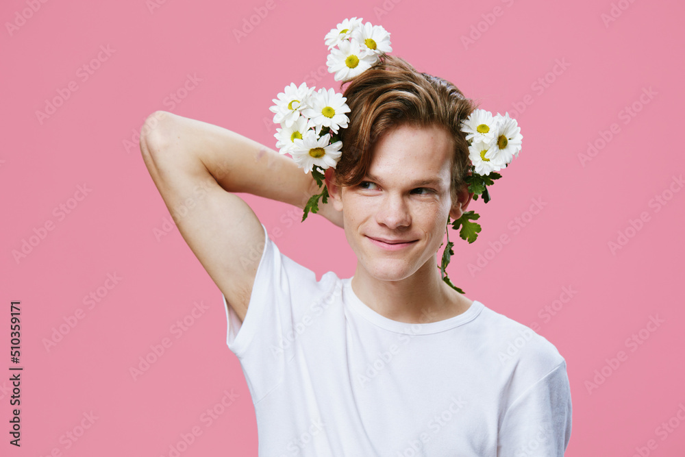 a cute, handsome guy in a white t-shirt poses happily with daisy ...