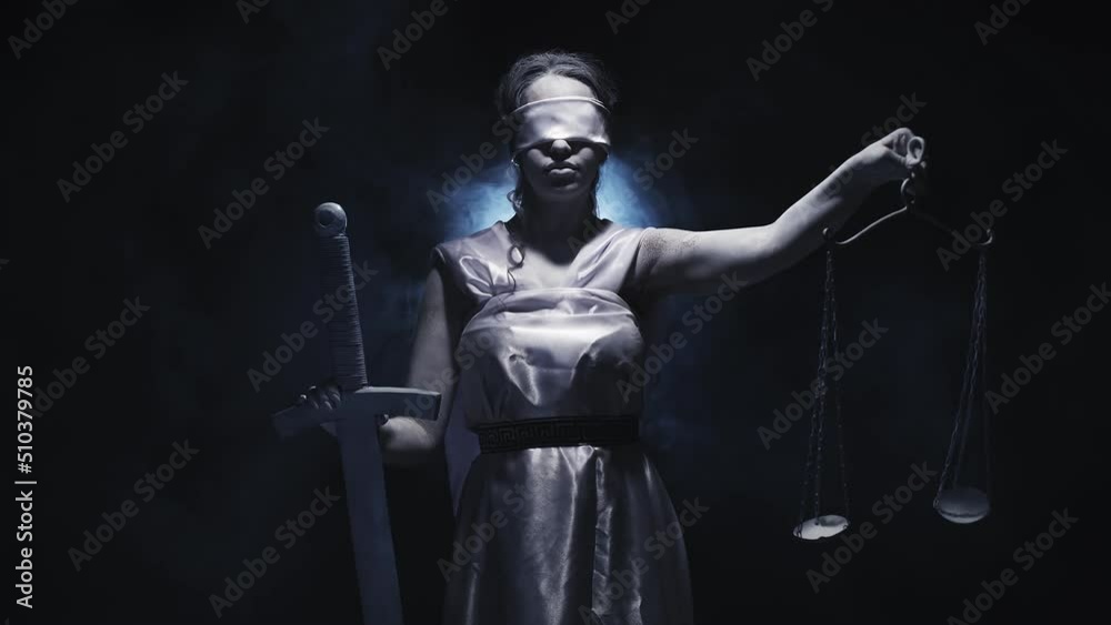 Woman in image of goddess justice stands on dark background in smoke ...