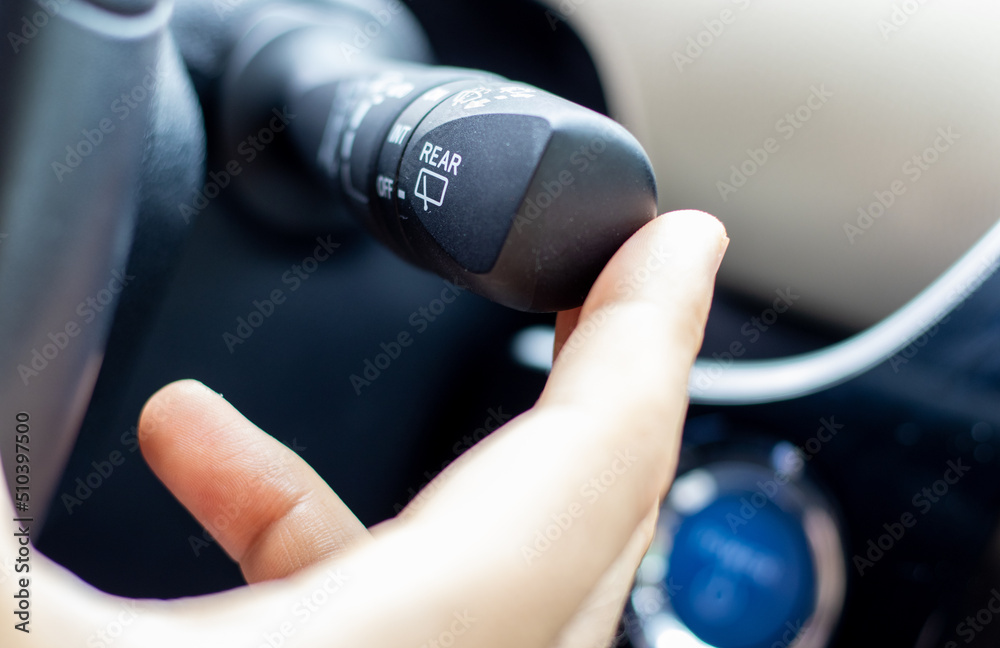 man hand on windshield wiper and washer controls,shifter or on steering ...