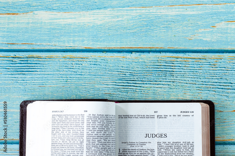 Judges open Holy Bible Book on a rustic wooden background with copy ...