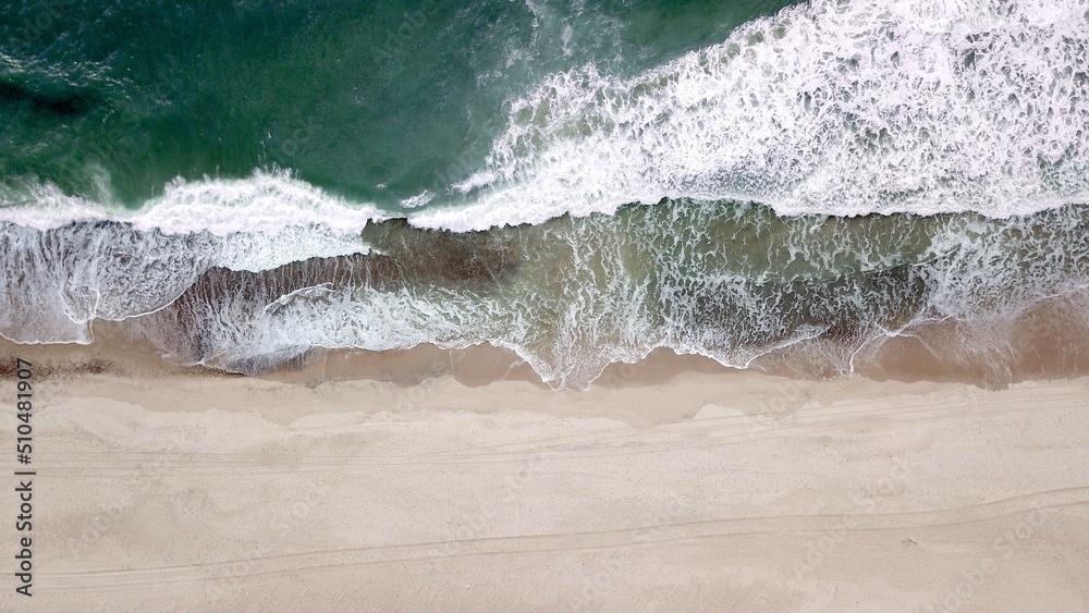 large waves of the ocean meet a beach, aerial view, sea level, coast ...