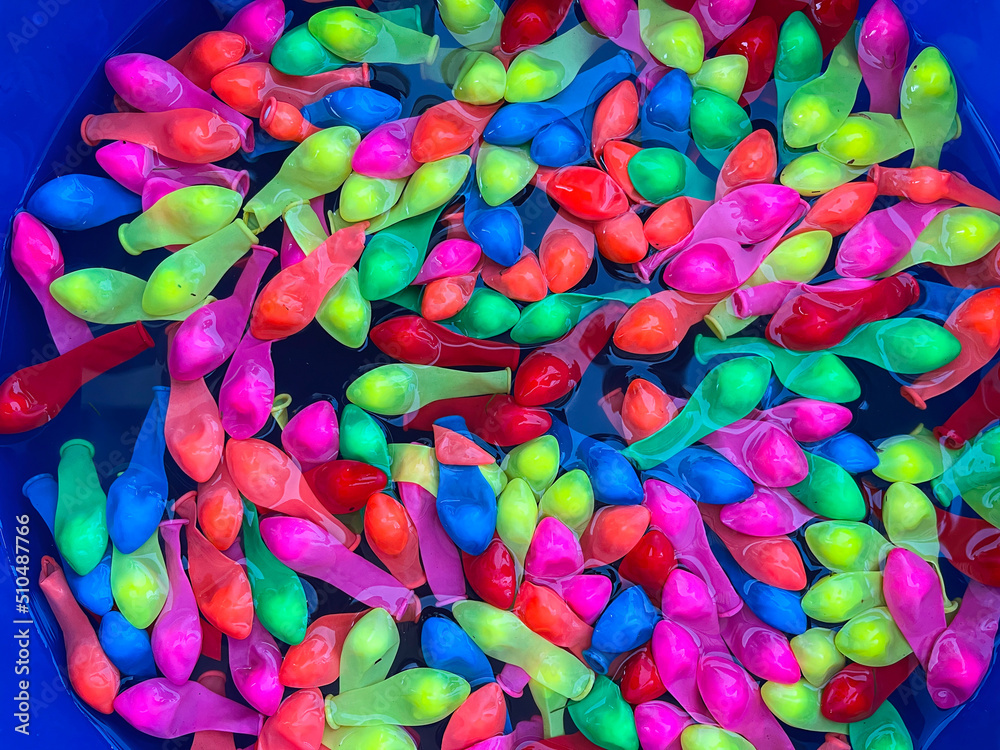 bucket full of water and deflated water balloons floating, balloon ...