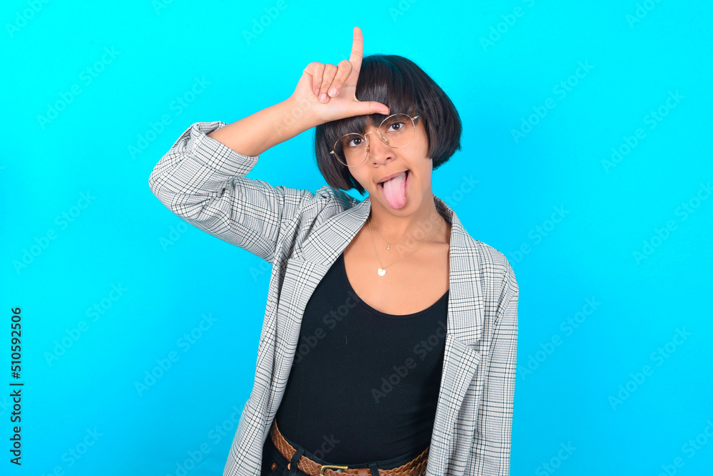 Funny young businesswoman with bob haircut wearing blazer against blue ...